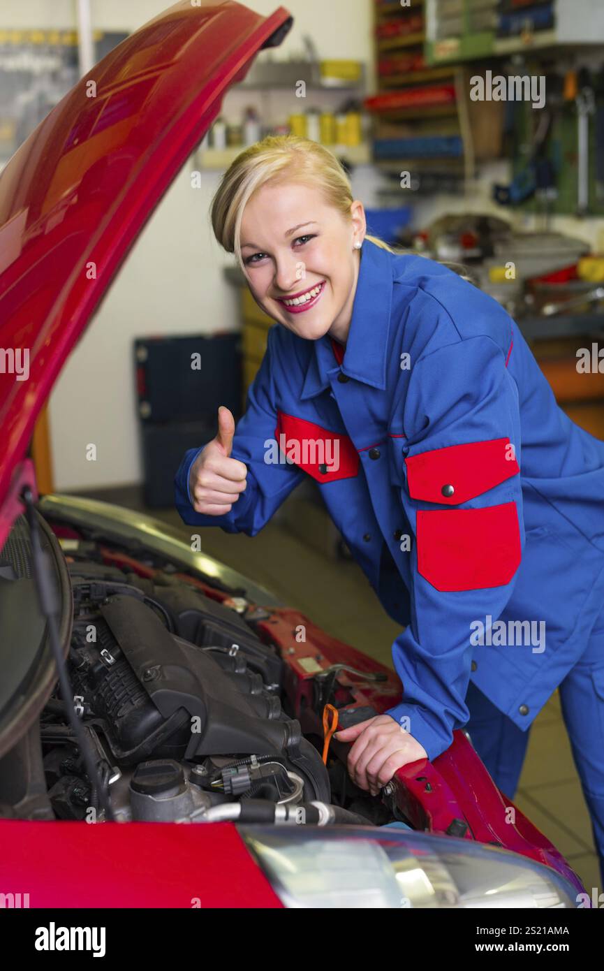 A young woman working as a mechanic in a car repair shop. Rare ...