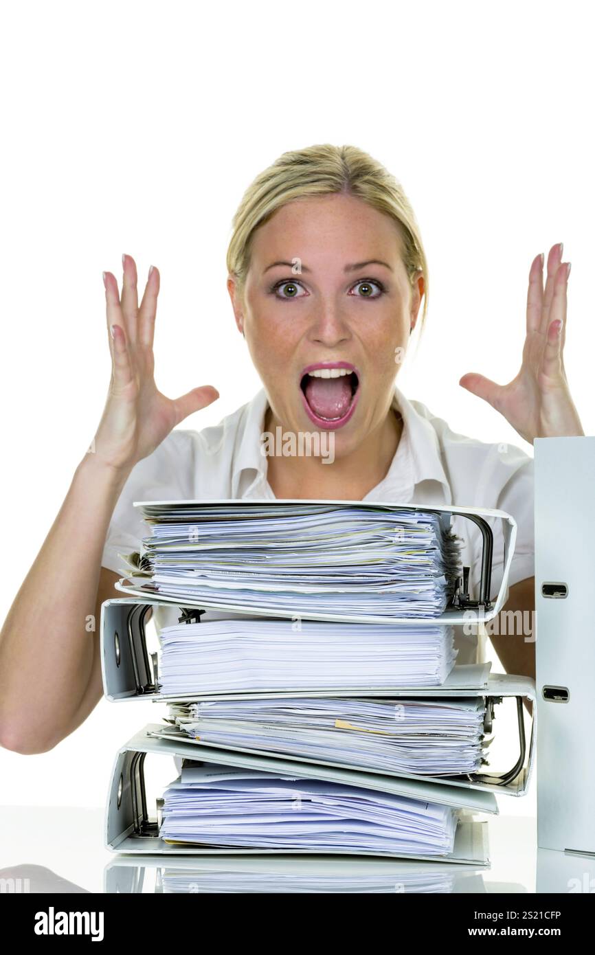 A young woman despairs in the office between many files and crumpled ...