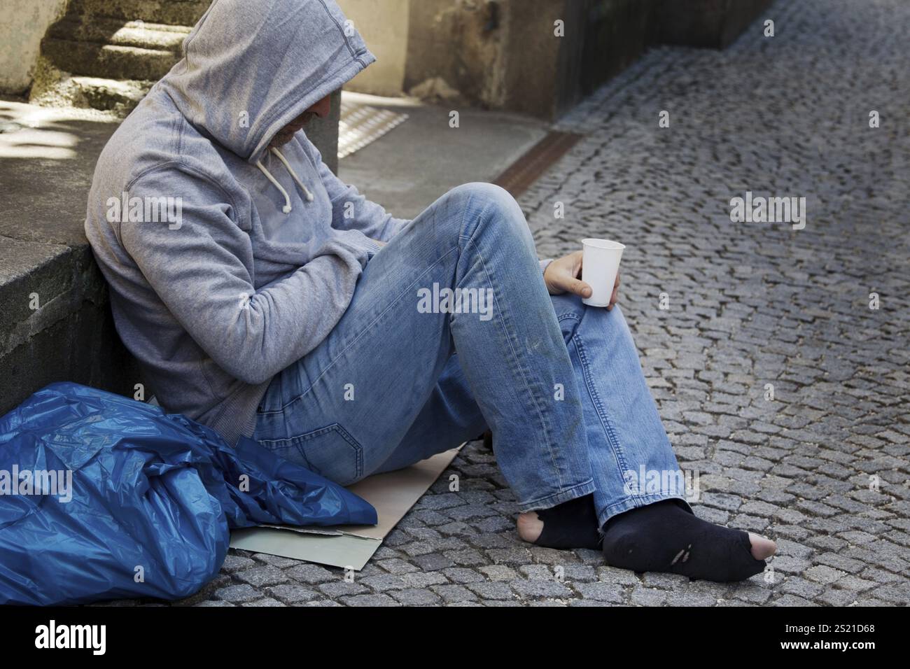 A homeless man seeks new work. Unemployed beggar lives on the street ...