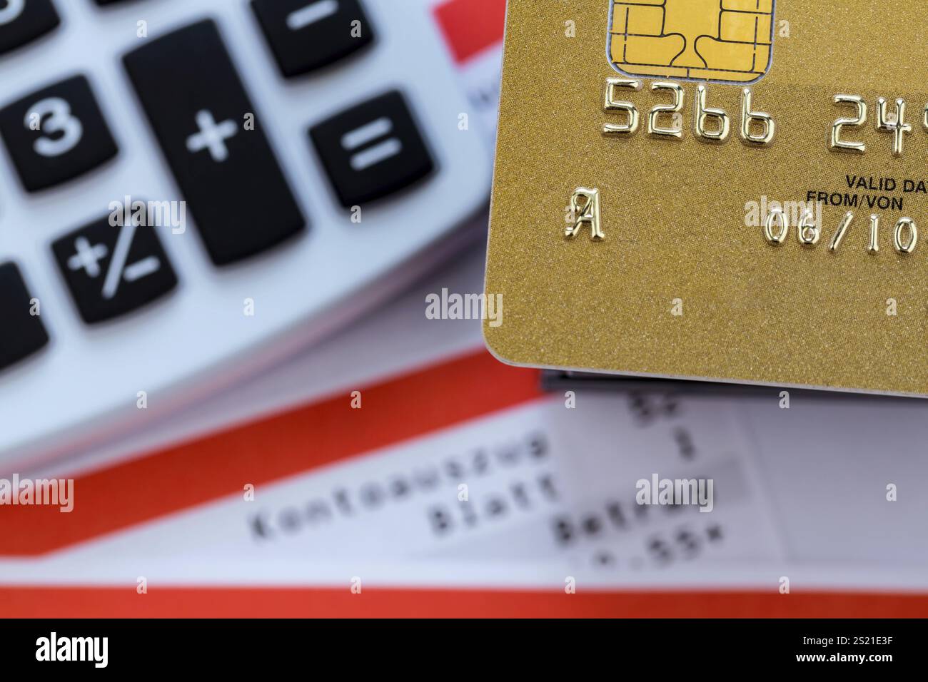 A gold credit card, bank statement and calculator. Symbolic photo for ...