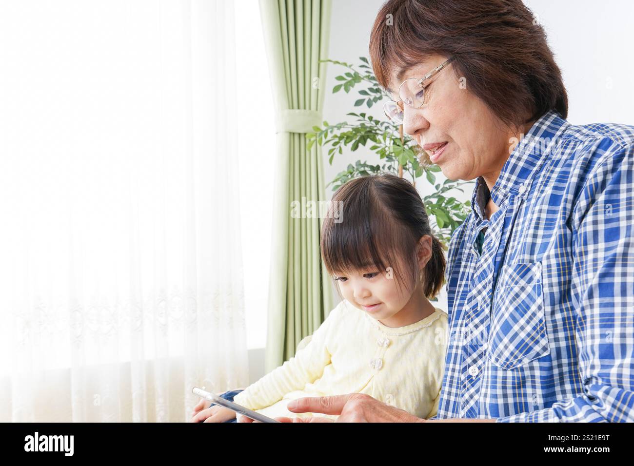 Child using a phone with grandma Stock Photo - Alamy