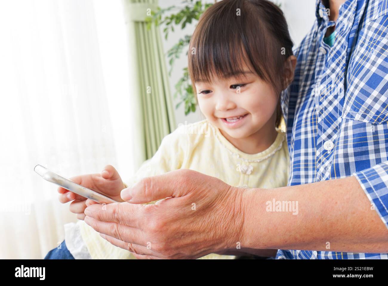 Child using a phone with grandma Stock Photo - Alamy