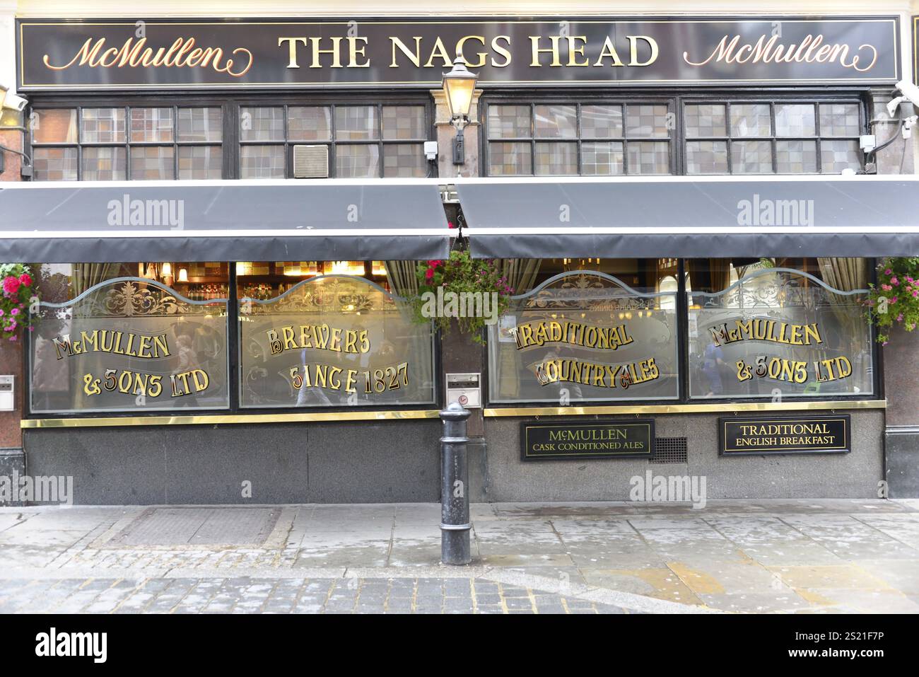 Traditional English pub with decorative window signs, London, London ...