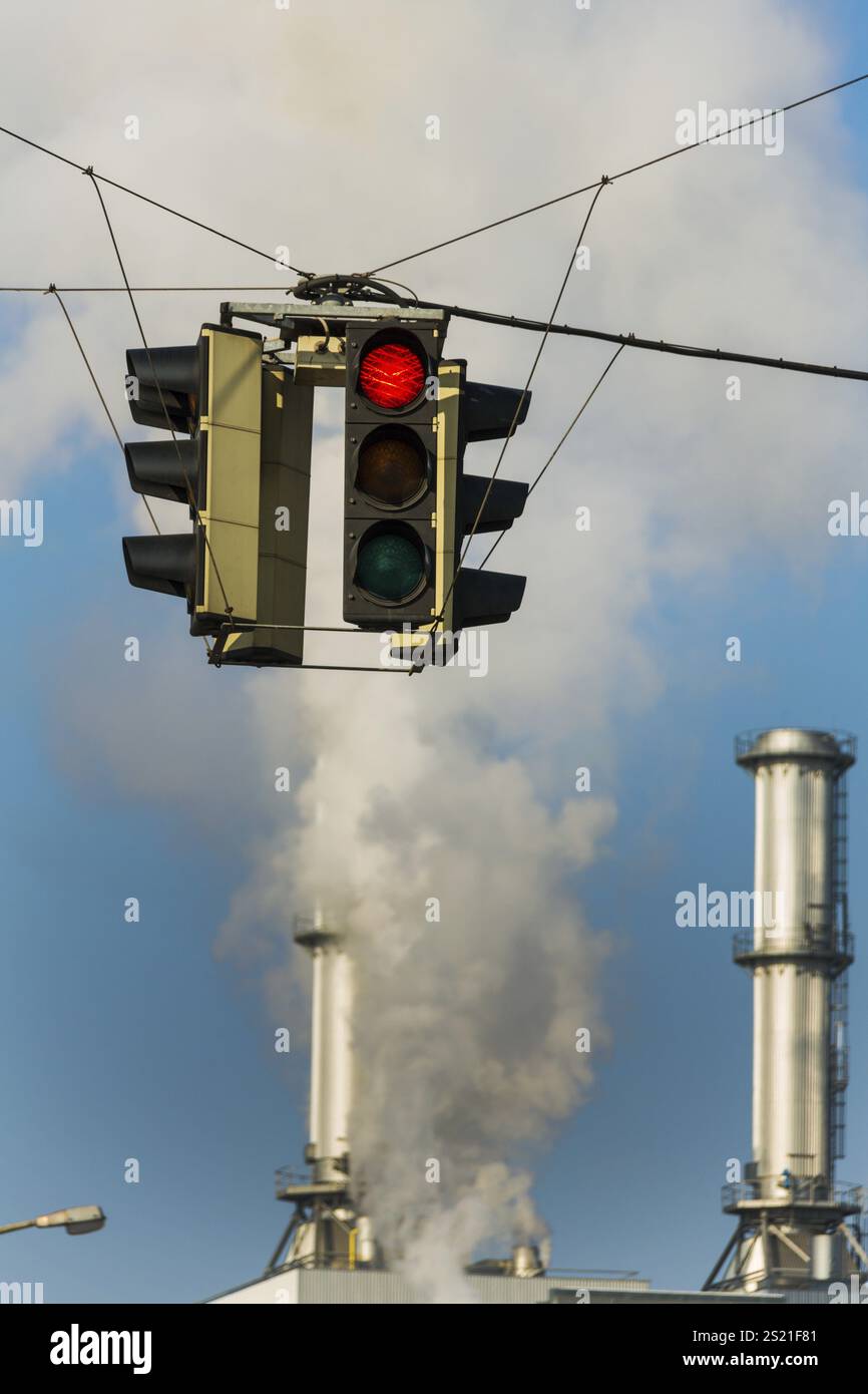 Industrial plant chimney and red traffic light. Symbolic photo for ...