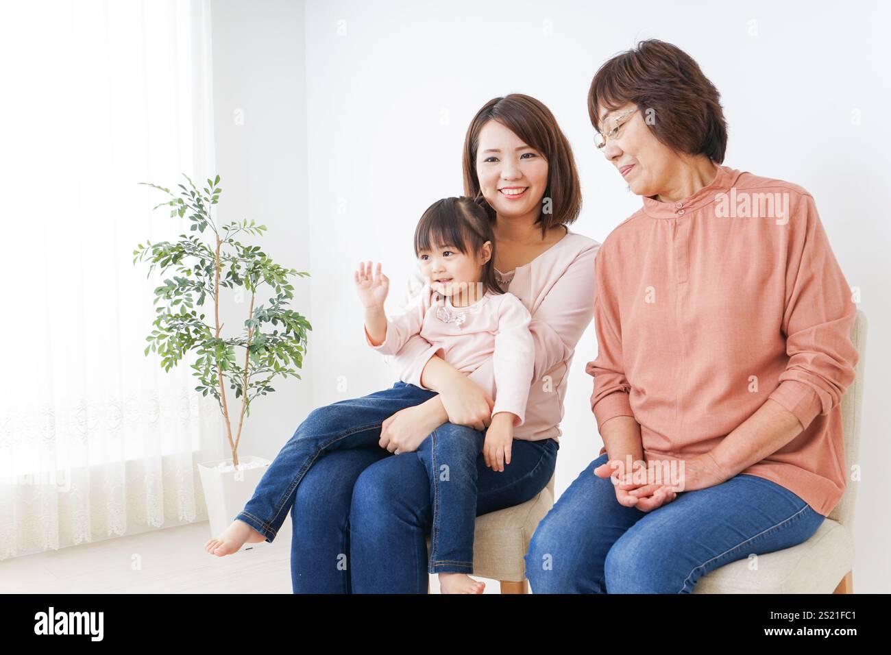 Three generations sitting on chairs Stock Photo - Alamy