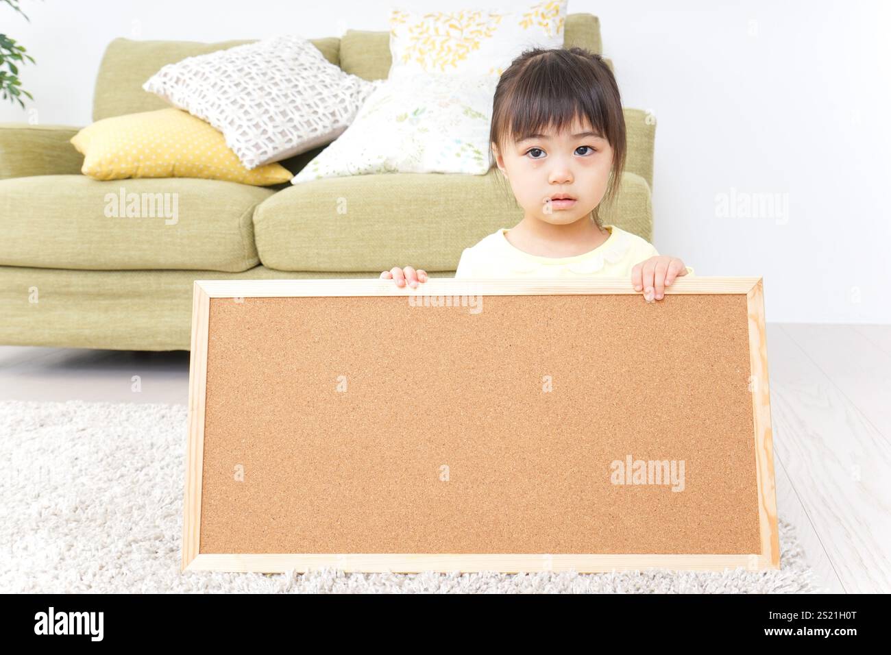 Crying child holding board Stock Photo - Alamy