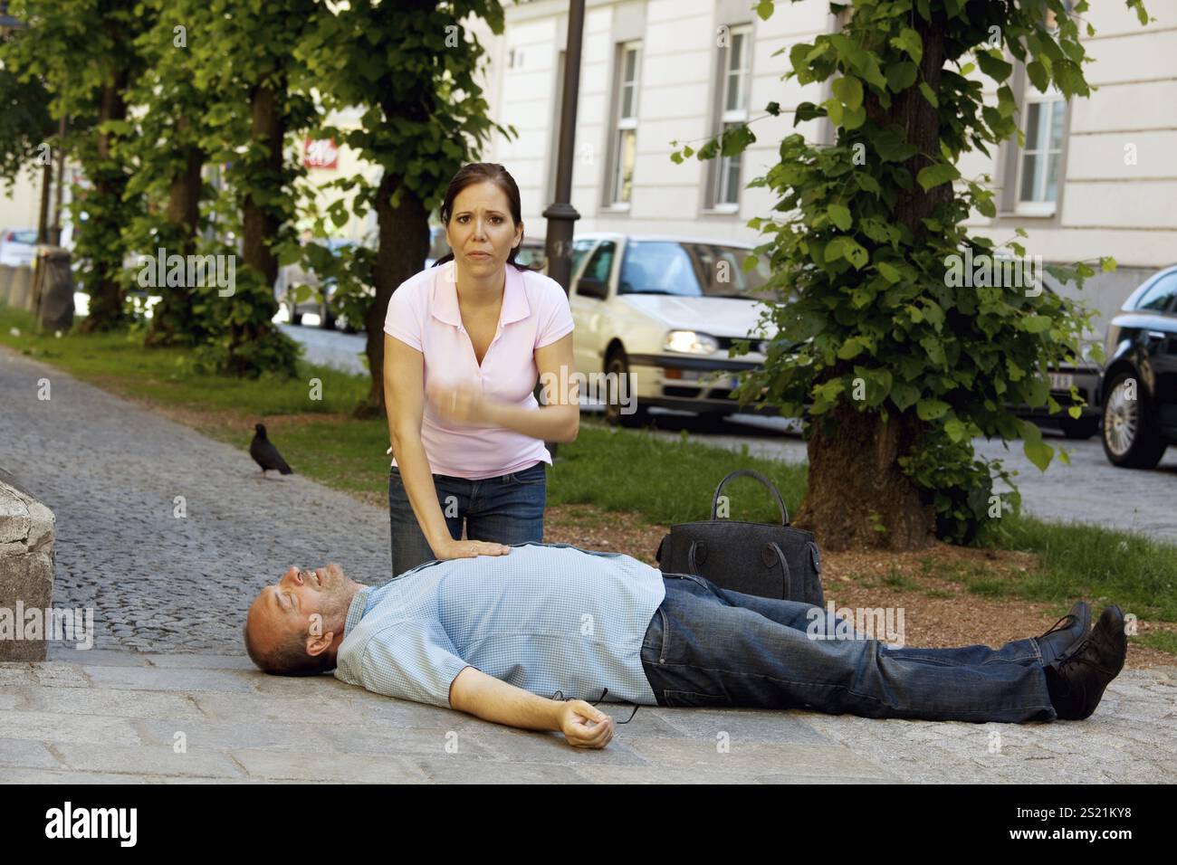 Woman gives first aid to a man with a heart attack on the street ...