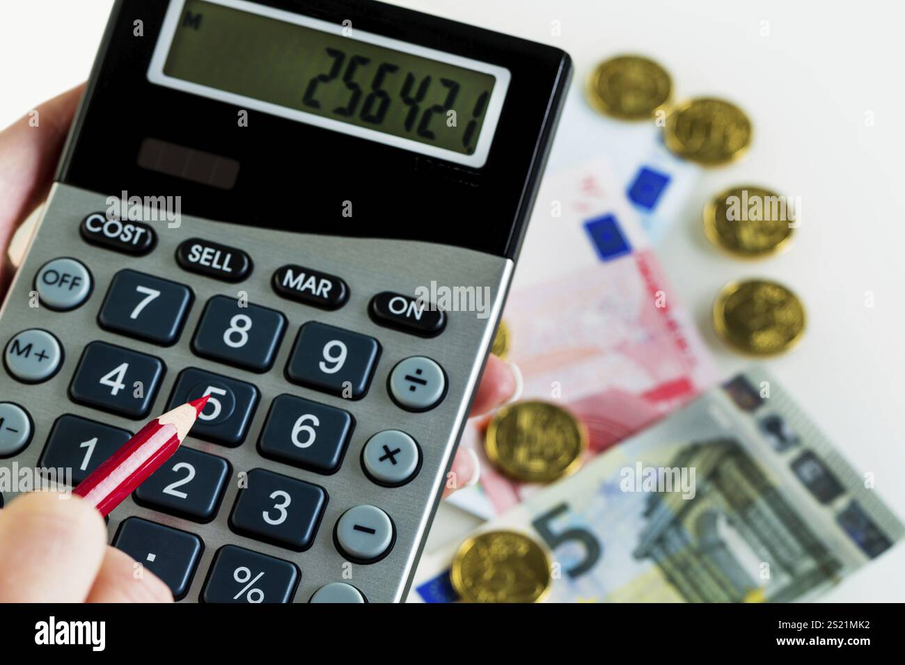 Hand with calculator and banknotes. Symbol photo for turnover, profit ...