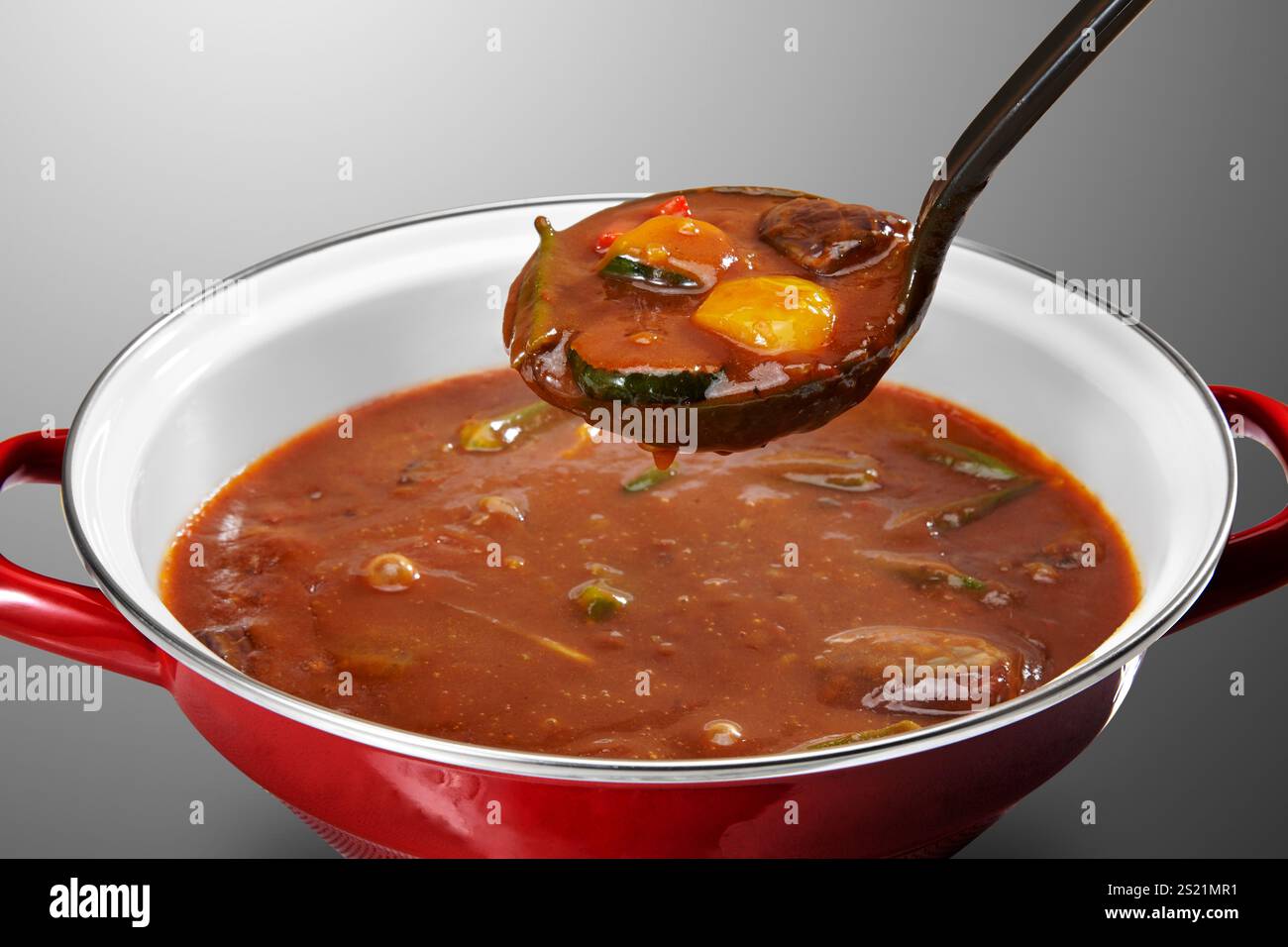 Scooping curry with a ladle Stock Photo - Alamy