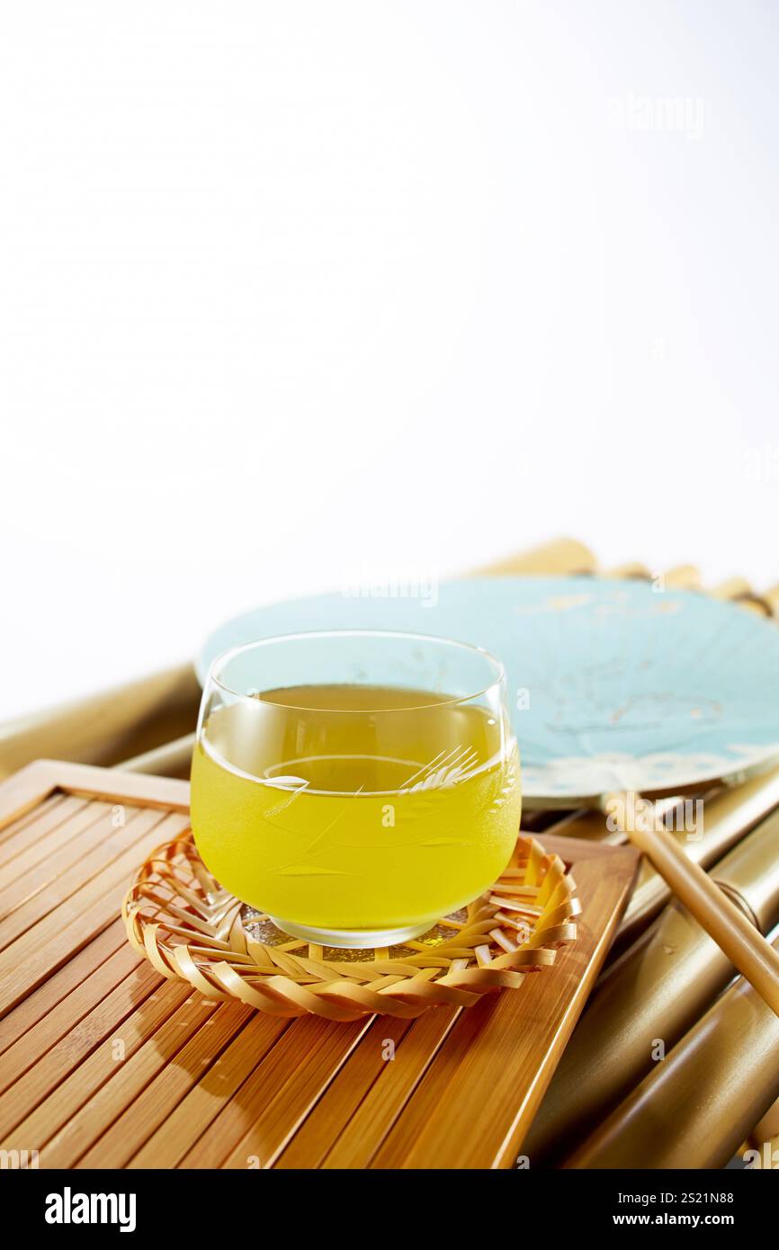 Cold tea and fan on bamboo bench Stock Photo - Alamy