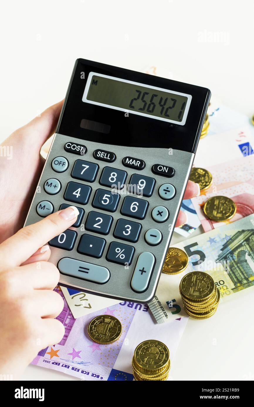 Hand with calculator and banknotes. Symbol photo for turnover, profit ...
