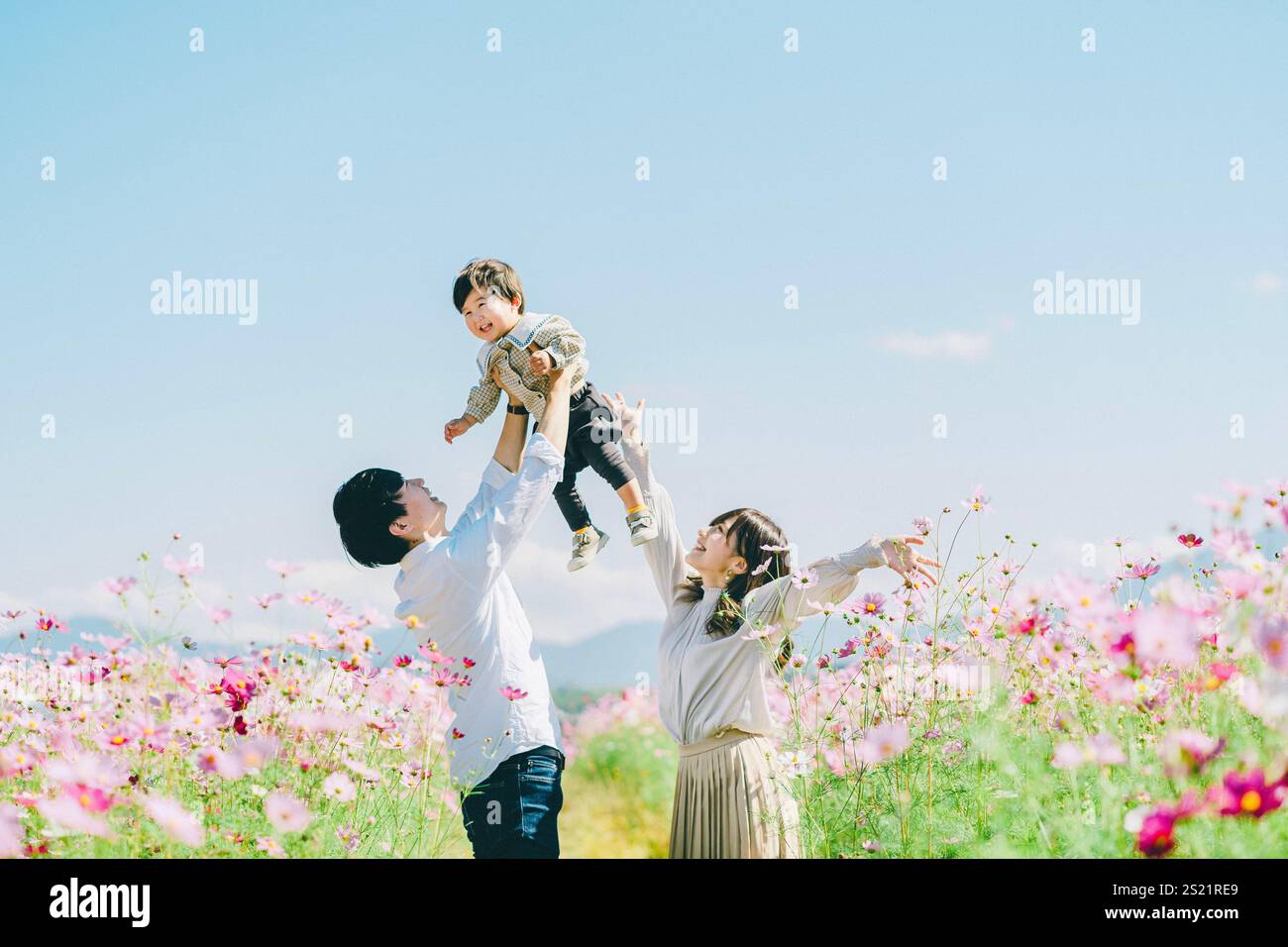Parents and children happily playing outdoors Stock Photo - Alamy