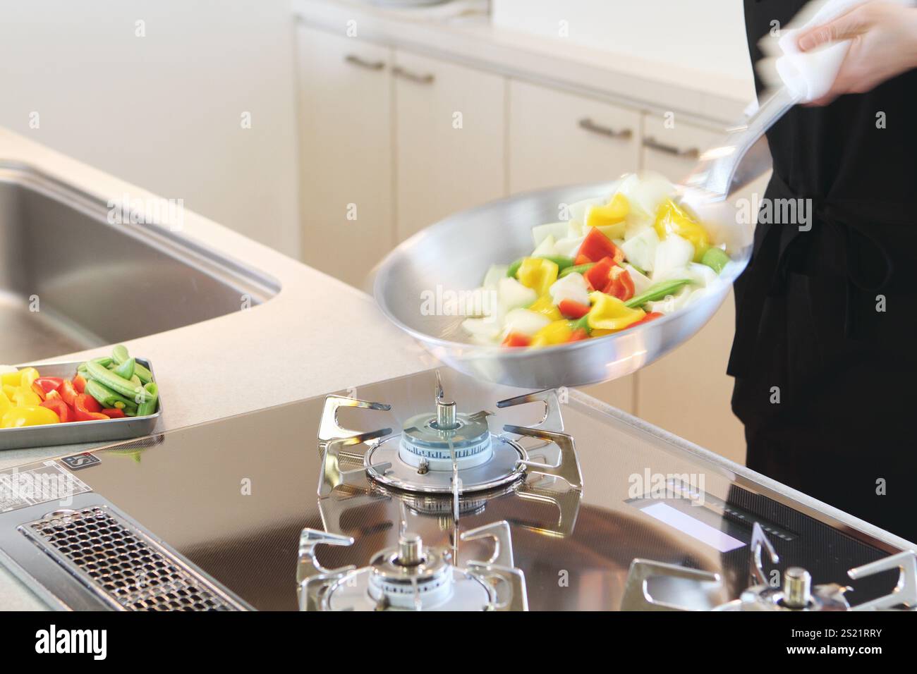 Cooking scene, swinging pan of stir-fried vegetables Stock Photo - Alamy