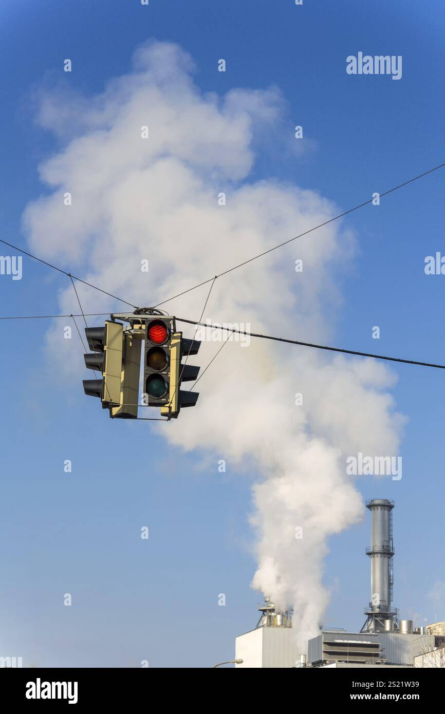 Industrial plant chimney and red traffic light. Symbolic photo for ...