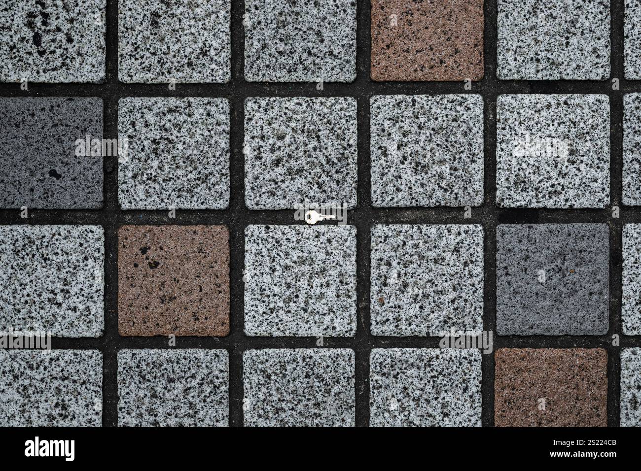 Small key on textured stone tiles Stock Photo - Alamy