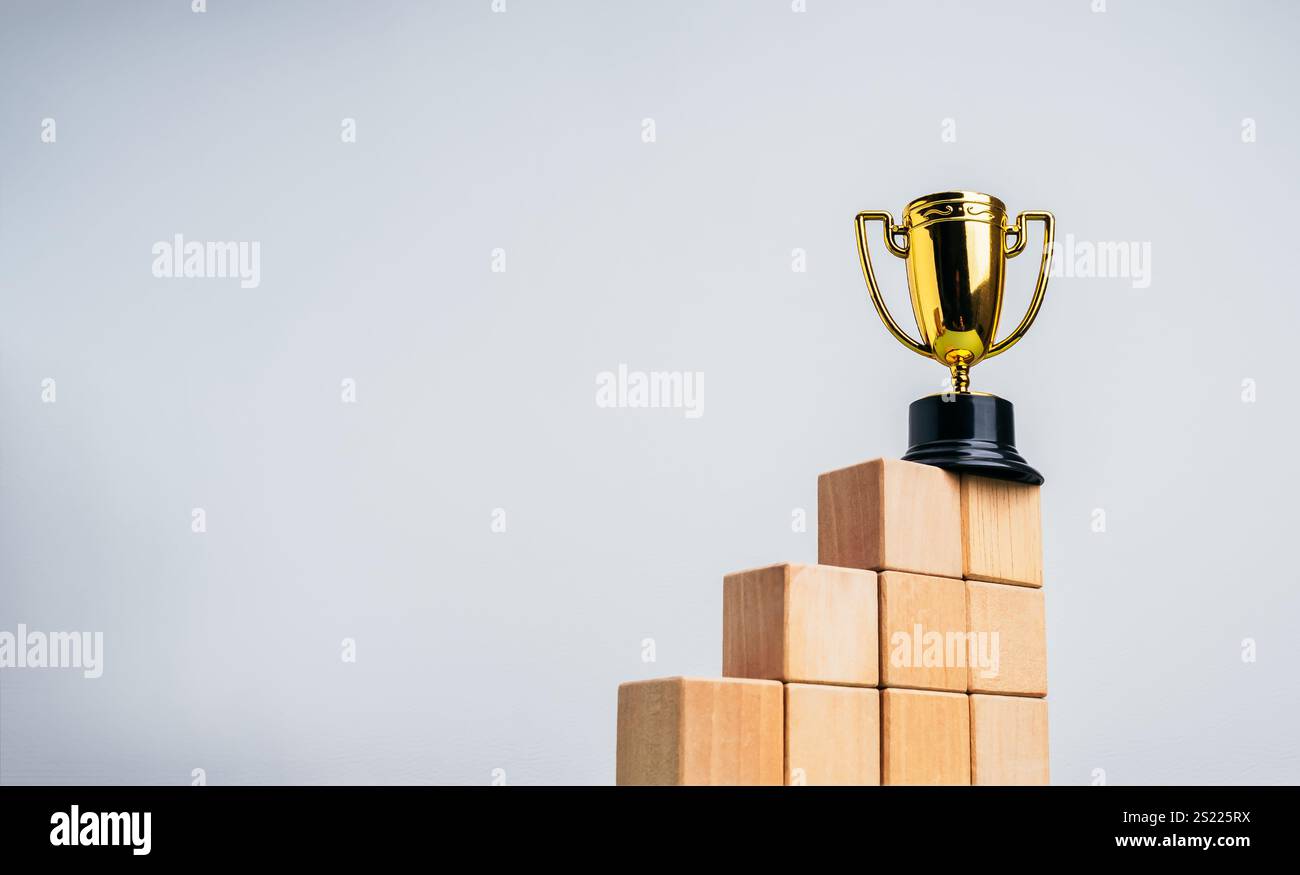 Gold trophy on top of wood cubes as bar graph chart steps on white ...