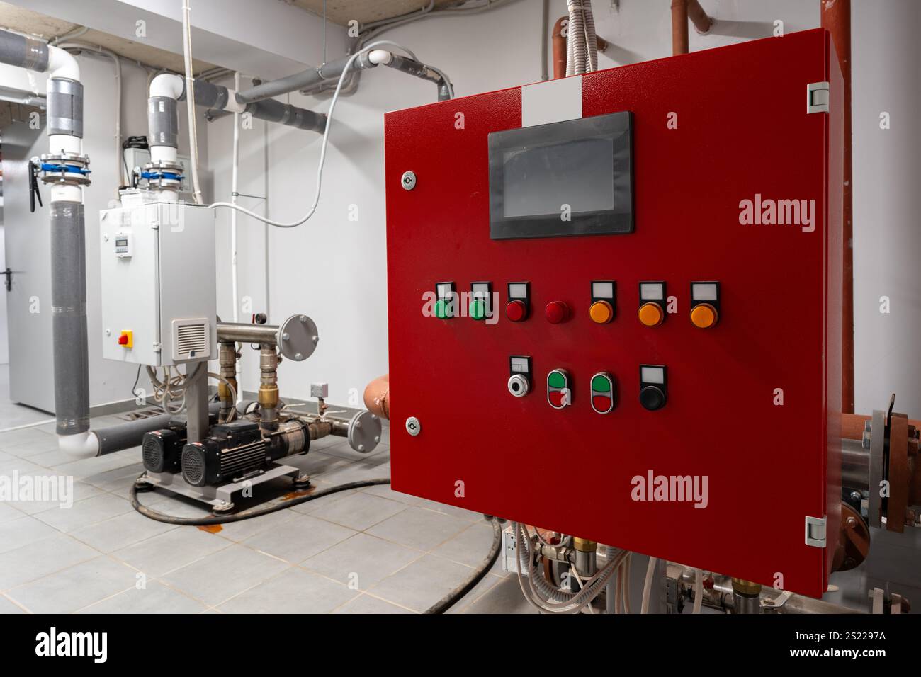 Control panel and equipment in a mechanical room focused on heating and ...