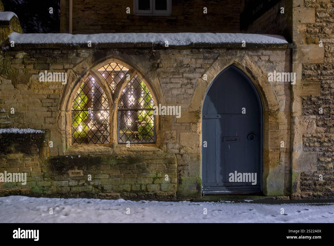 Arched door and window at night in the winter snow. Stow on the Wold ...