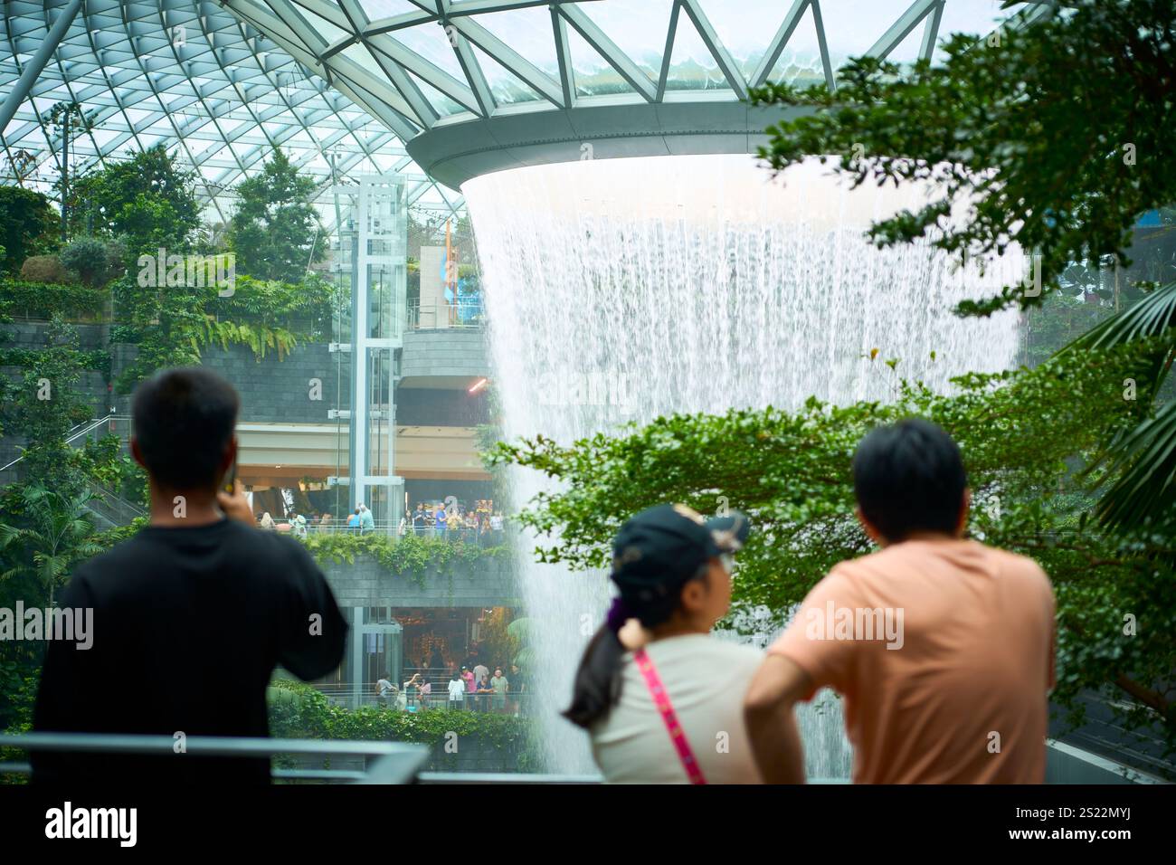 Tourists enjoying the impressive rain vortex waterfall inside the jewel ...