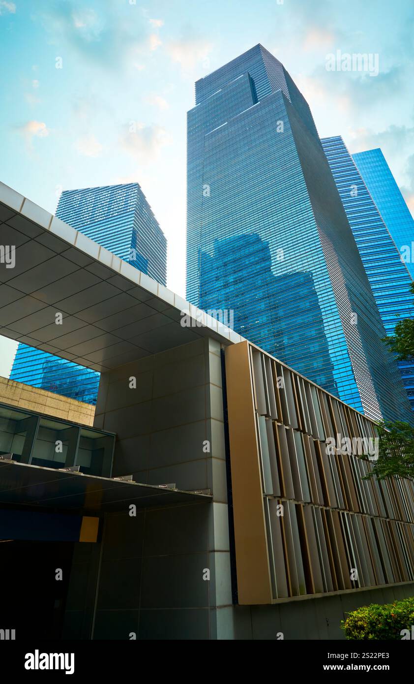 Modern glass skyscrapers towering over a connecting bridge in singapore ...