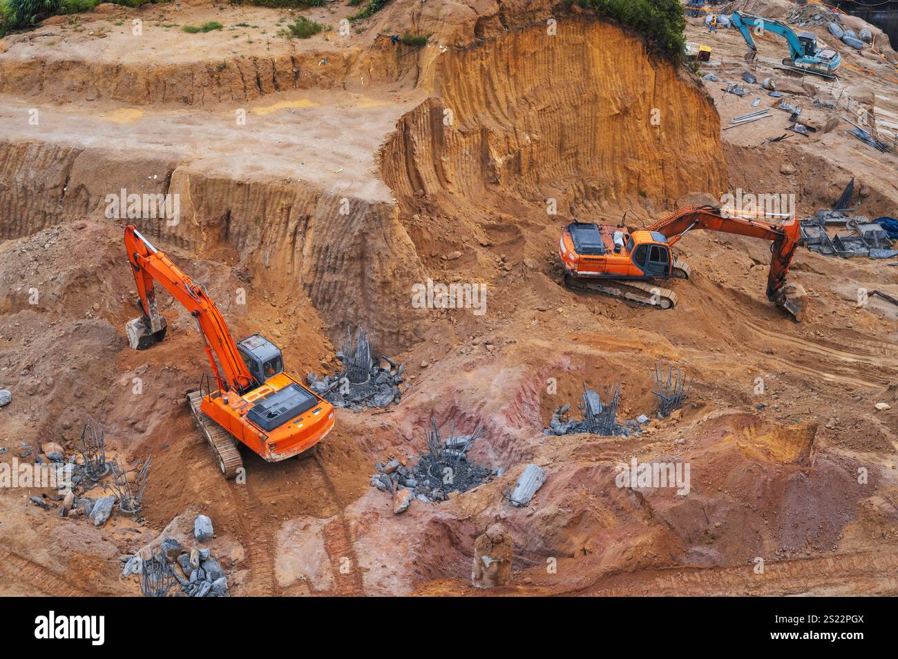 Excavators dig the ground in the foundation pit of a building on a ...