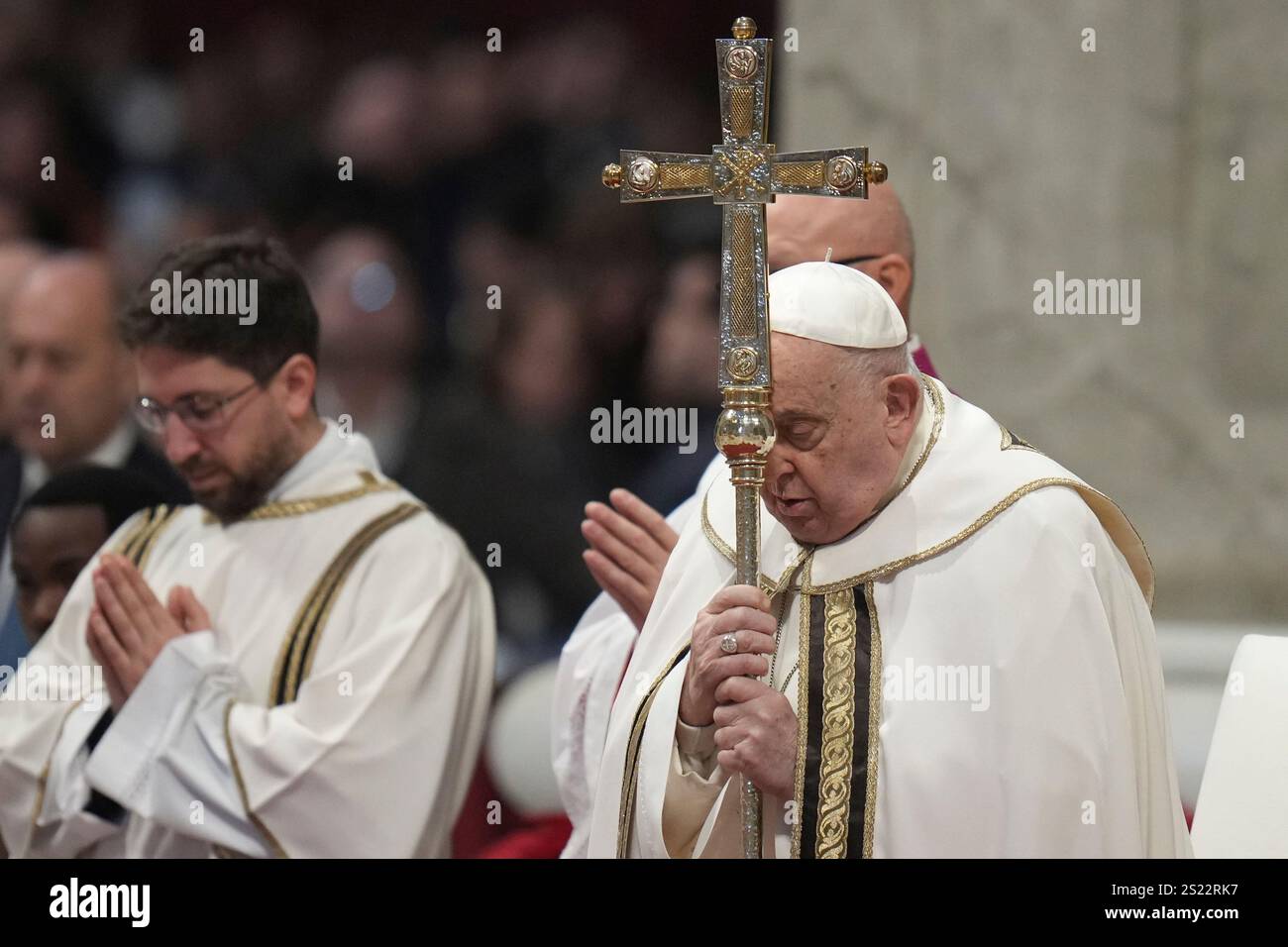 Pope Francis holds the cross as he presides over an Epiphany mass in St ...