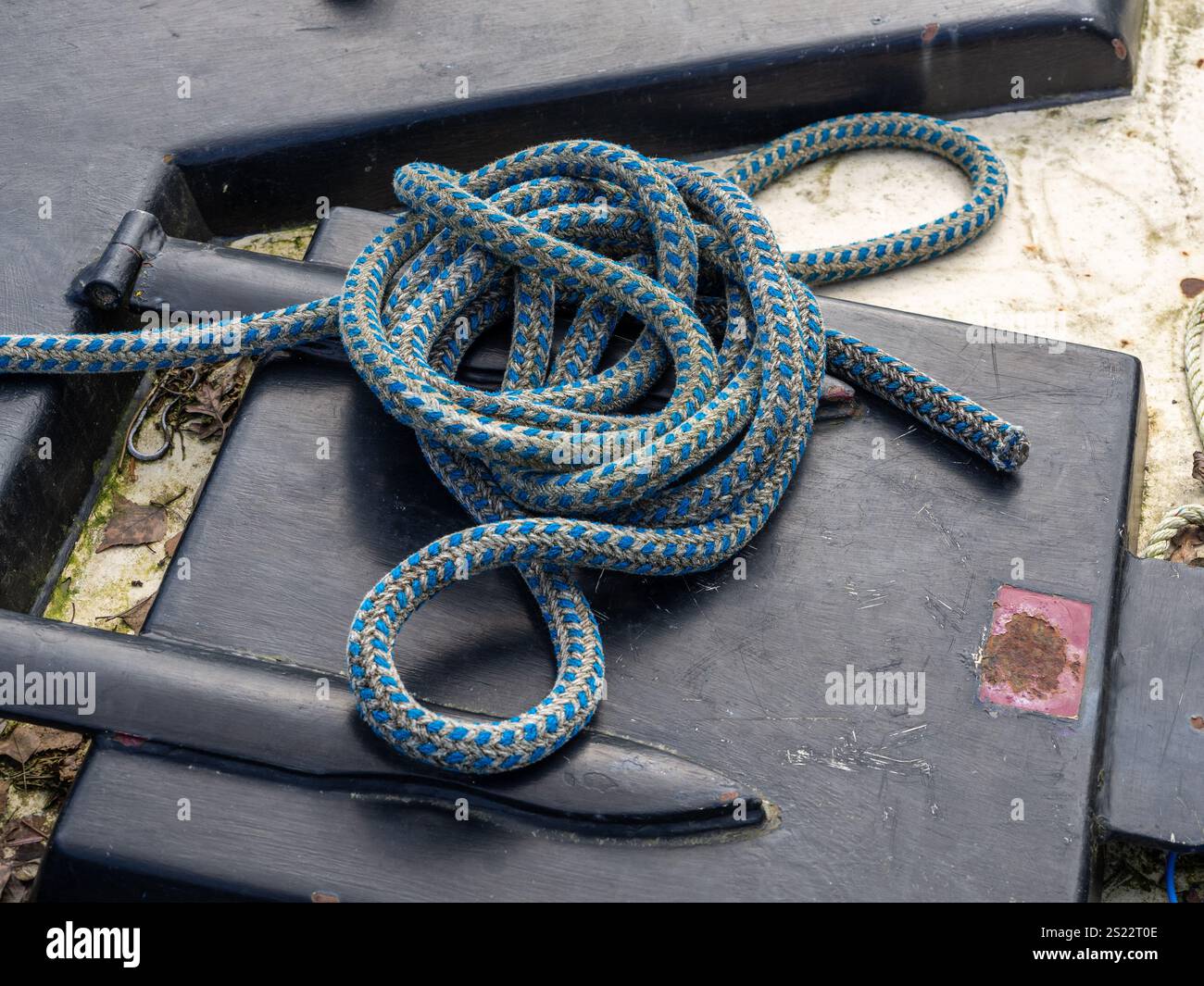 Coiled blue and white striped rope on the deck of a narrowboat, UK ...