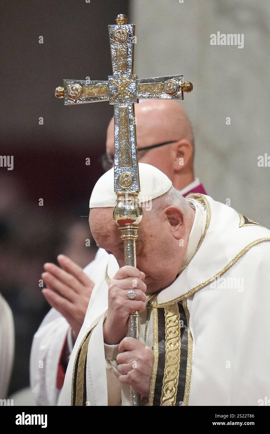 Pope Francis holds the cross as he presides over an Epiphany mass in St ...