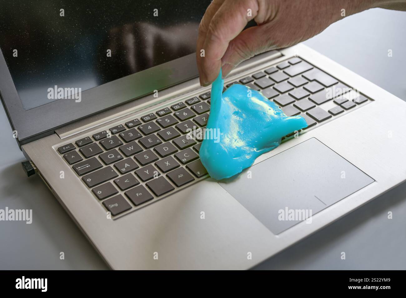 Cleaning a laptop keyboard with soft blue absorbing gel or compound to ...