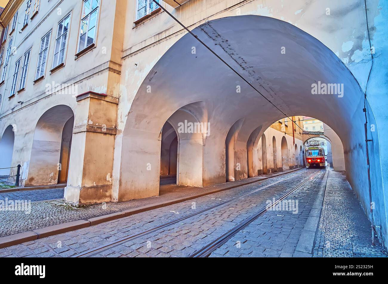The vintage red tram, running through the arched passage on Letenska ...
