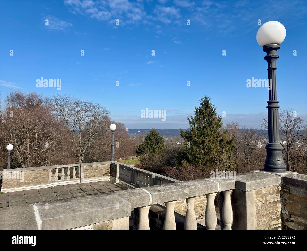 Elevated stone terrace with vintage lamp posts and a clear blue sky ...