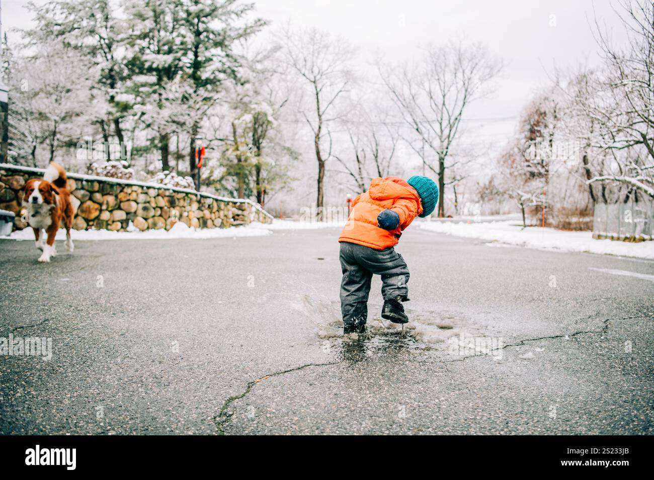 Child splashing in icy puddle Stock Photo - Alamy