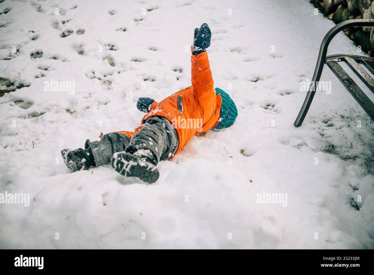 Child lying in snow, arm raised Stock Photo - Alamy