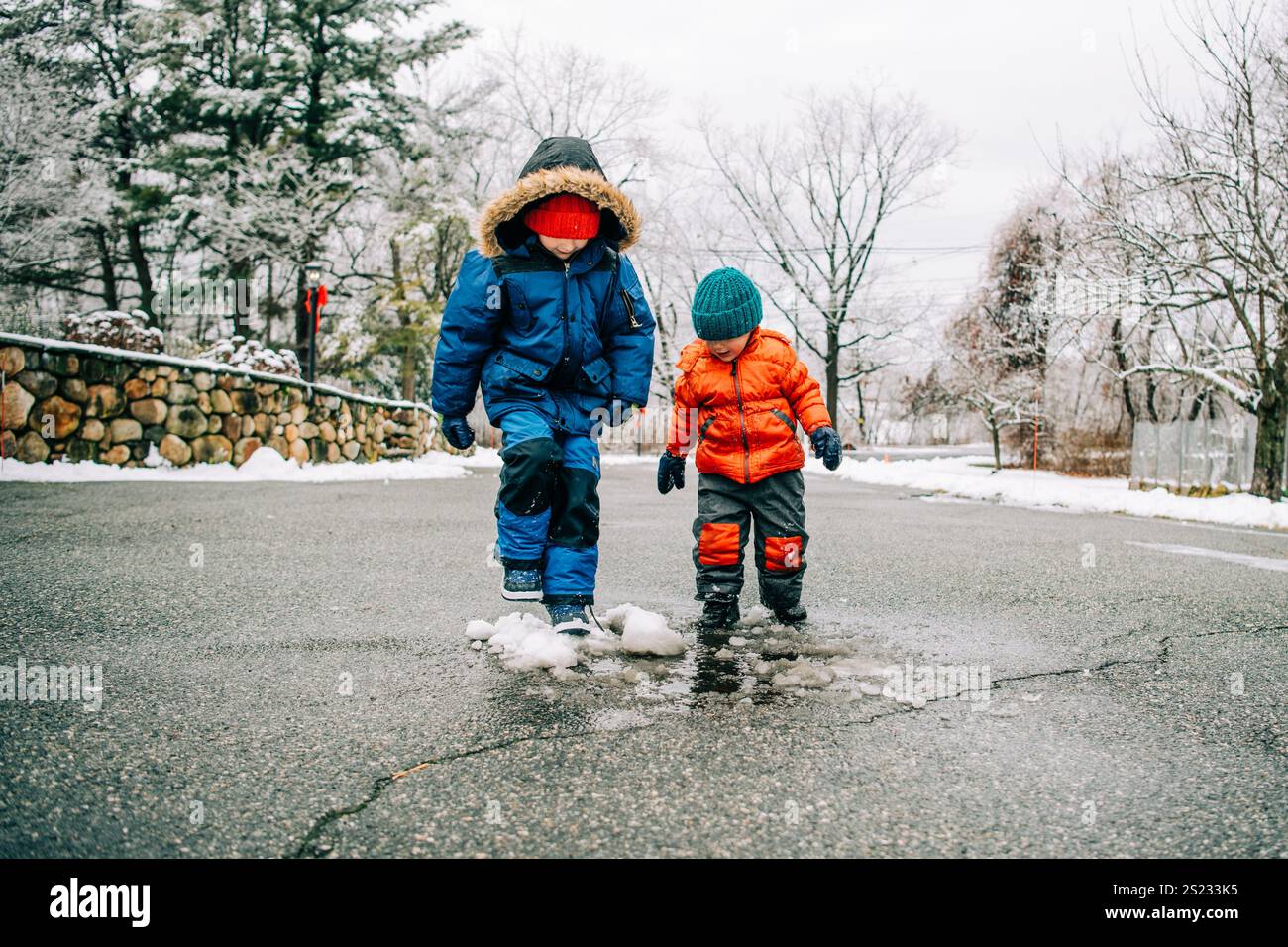 Children jumping in a winter puddle Stock Photo - Alamy