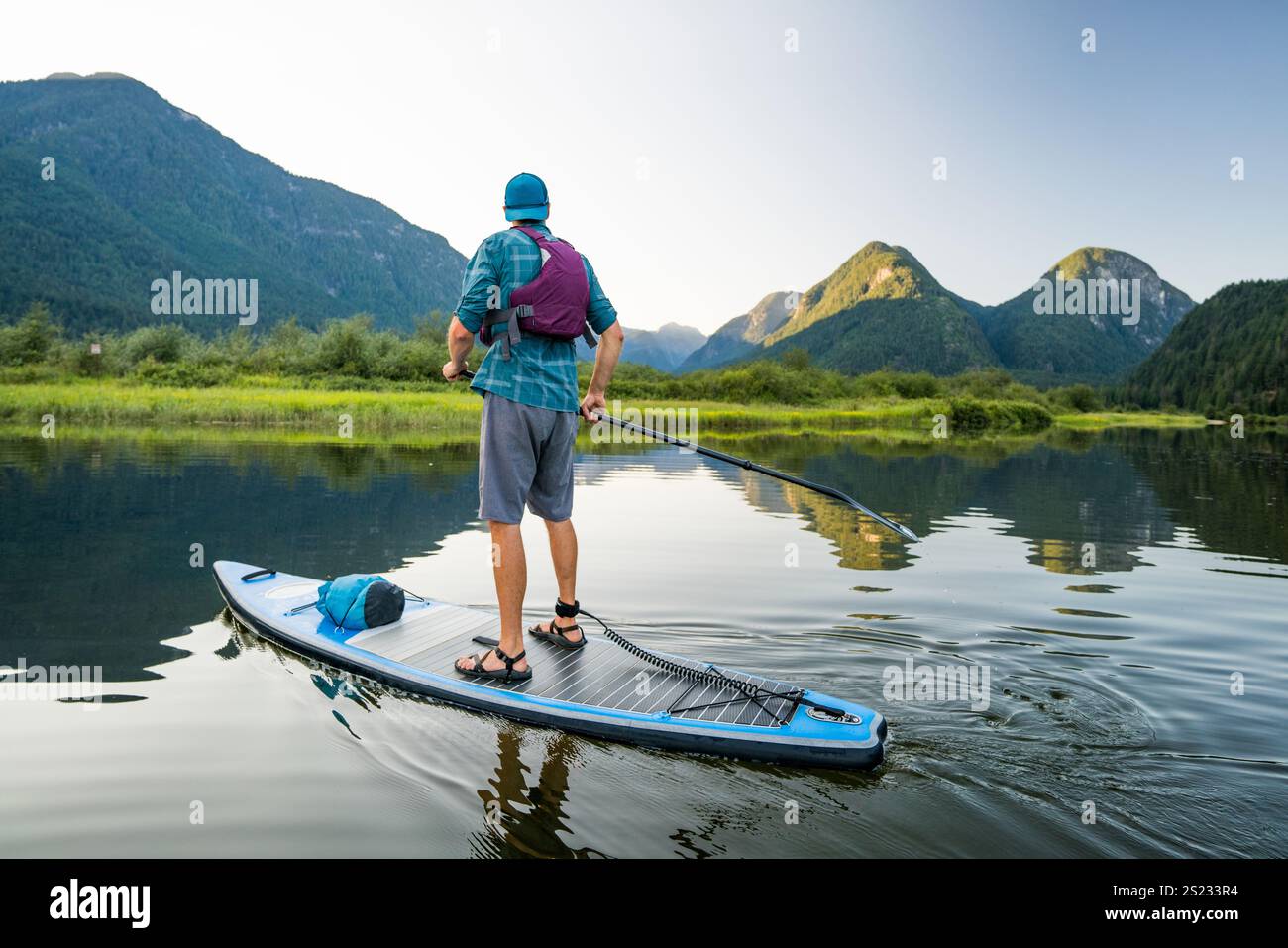 Rear view of man exploring river on paddle board Stock Photo - Alamy