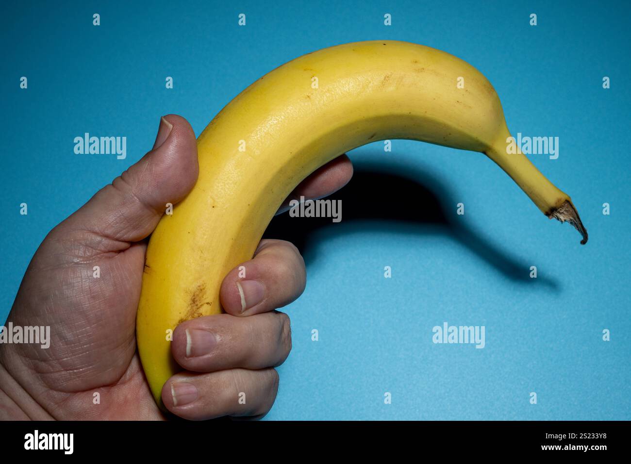 Hand hält gelbe Banane vor blauem Hintergrund , Deutschland, 05.01.2025 ...