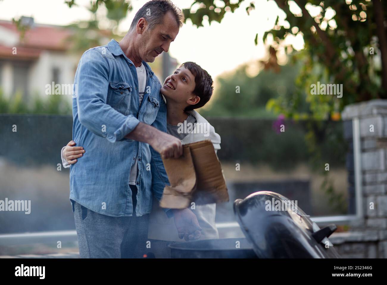 Father and son bonding over a backyard barbecue Stock Photo - Alamy