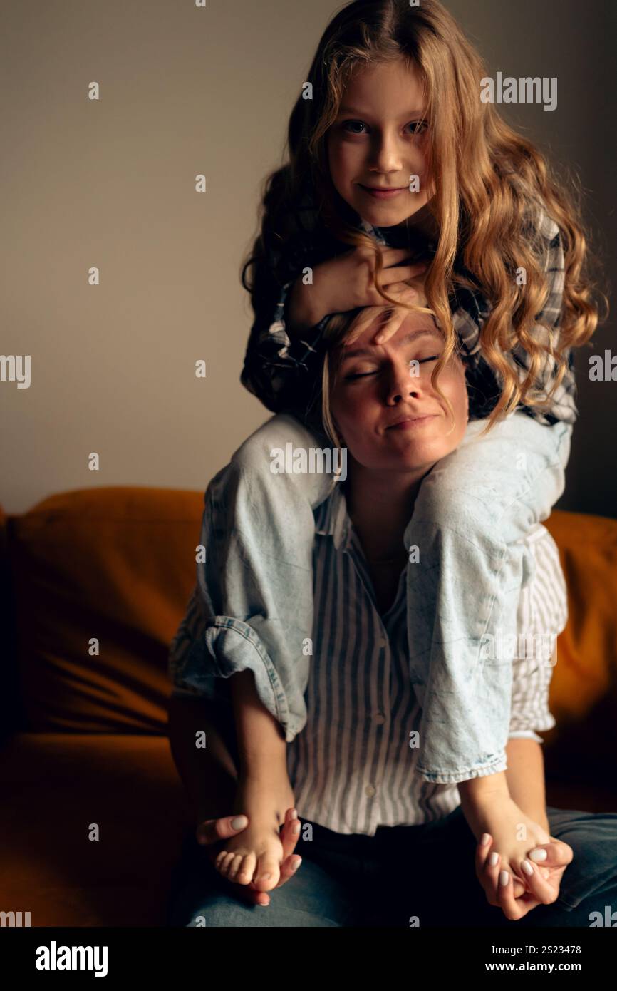 Mom and daughter hugging and laughing, sit on the neck Stock Photo - Alamy
