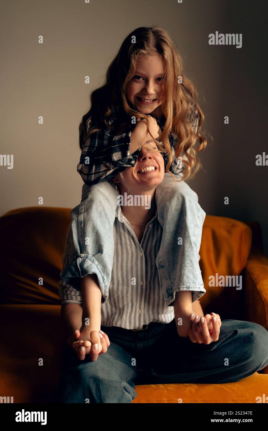 Mom and daughter hugging and laughing, sit on the neck Stock Photo - Alamy