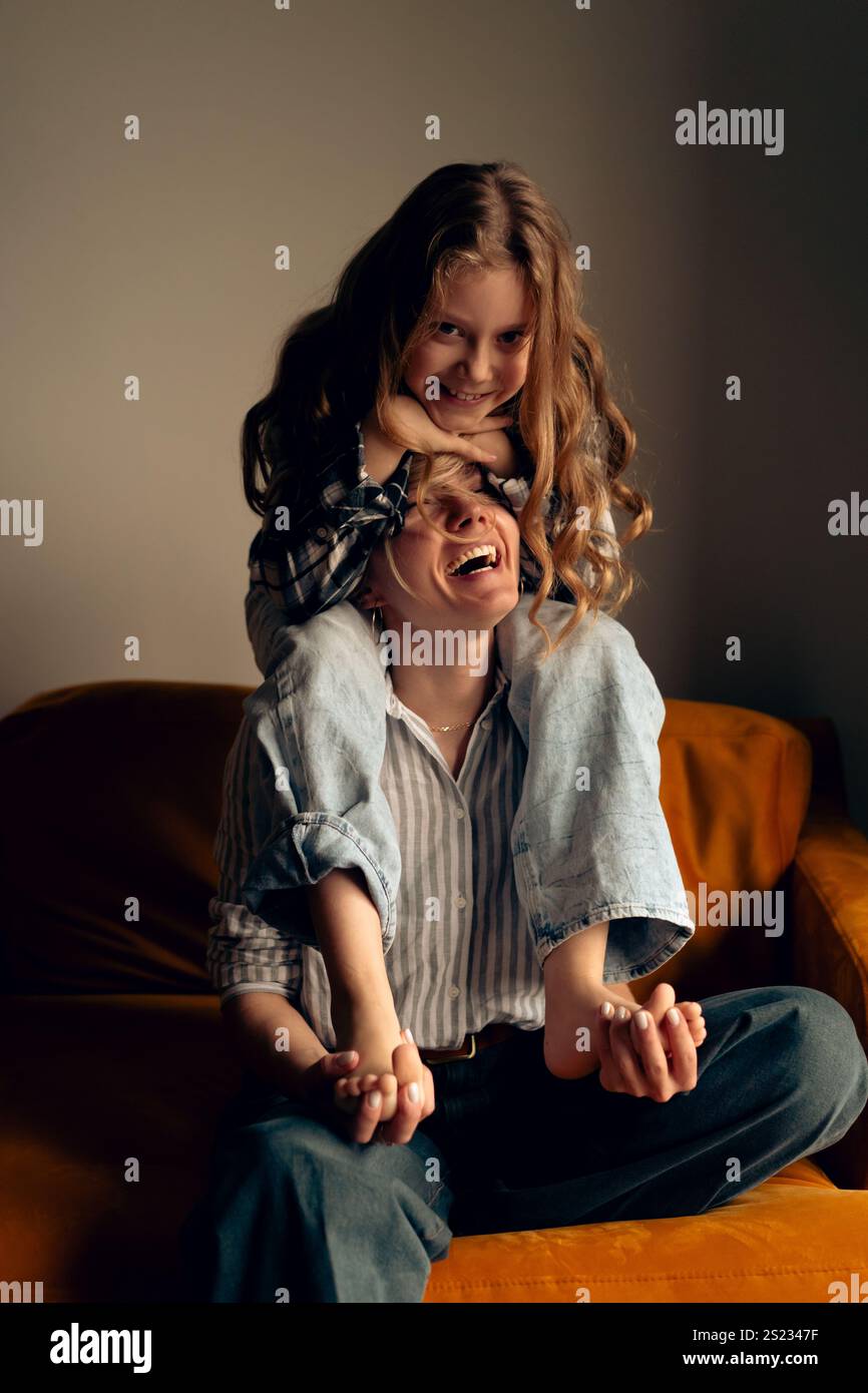 Mom and daughter hugging and laughing, sit on the neck Stock Photo - Alamy
