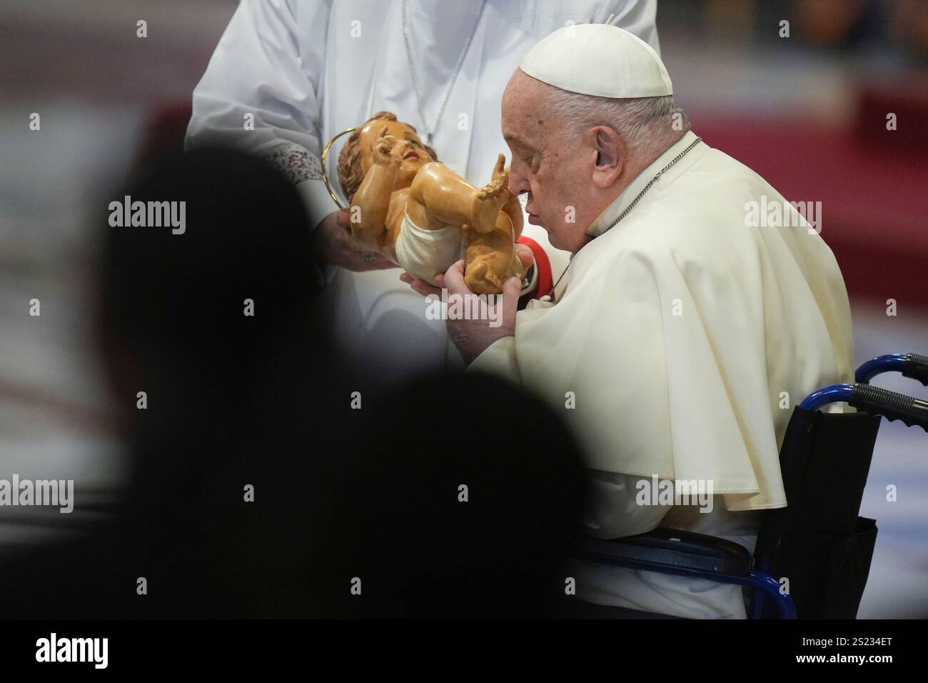 Pope Francis kisses the baby Jesus as he presides over an Epiphany mass ...