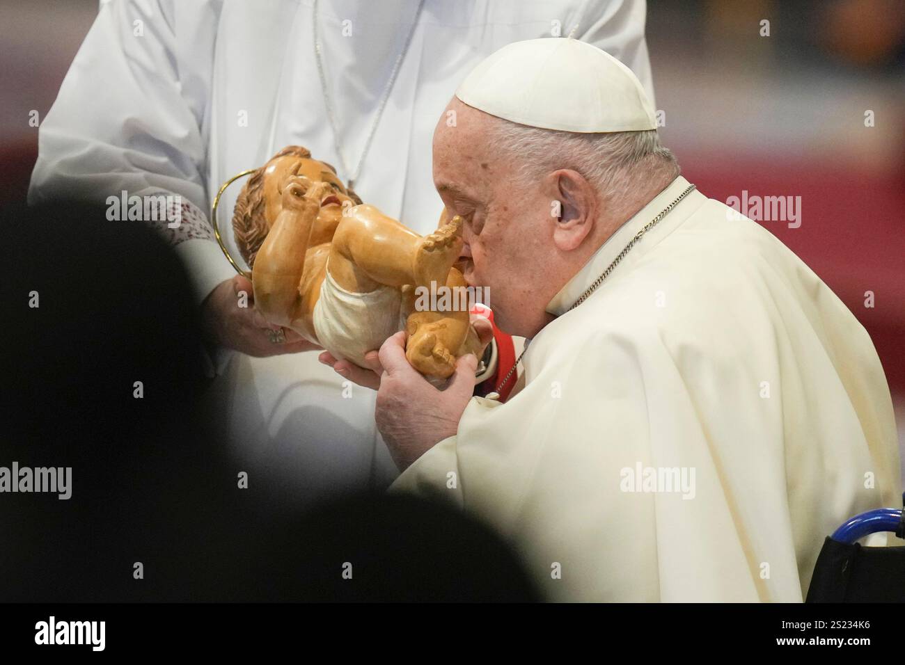 Pope Francis kisses the baby Jesus as he presides over an Epiphany mass ...