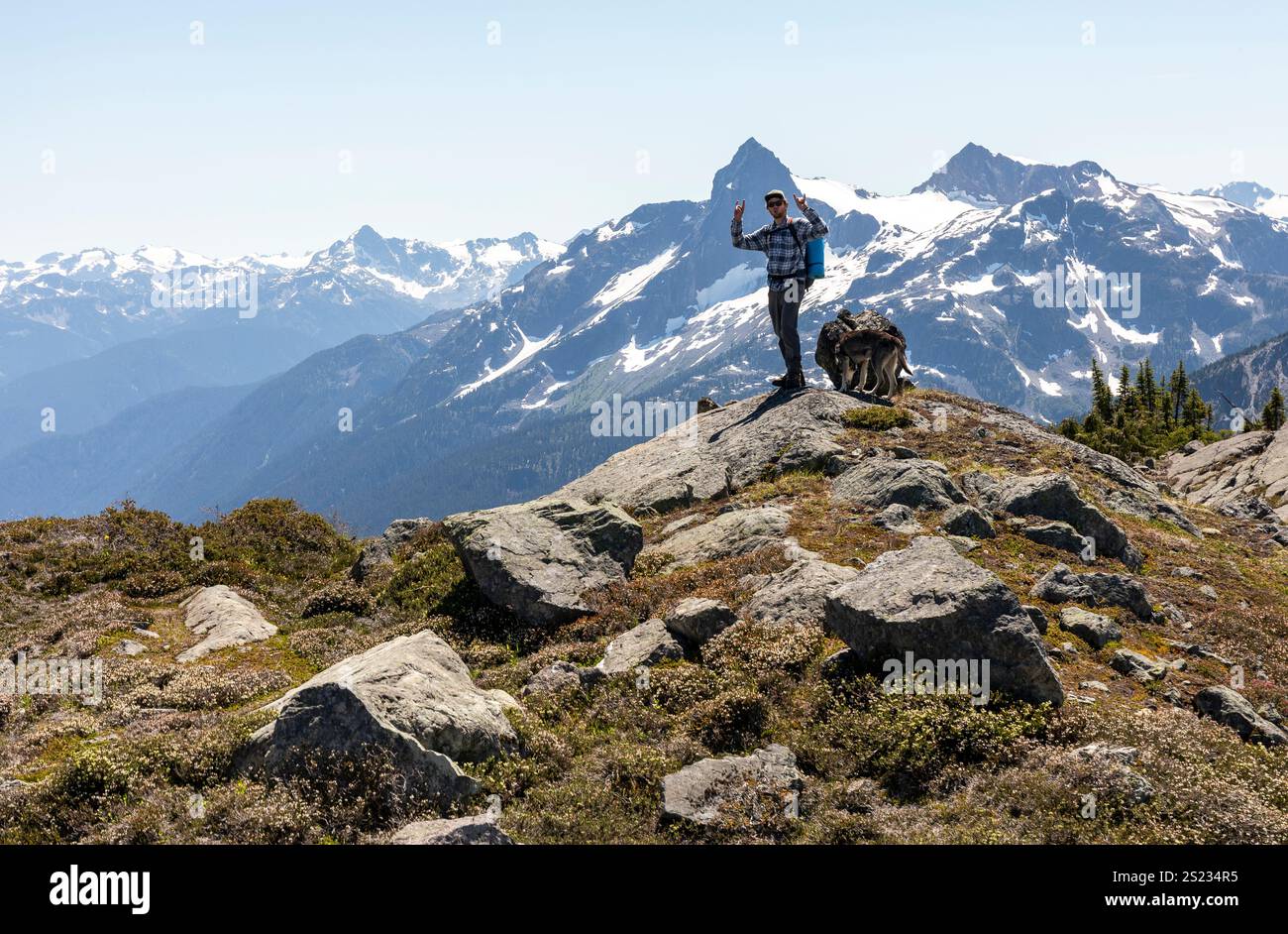 Solo man hiking in rugged mountain terrain with Snow-Capped Peaks Stock ...