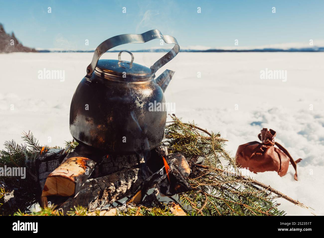 Rustic Coffee Kettle Boiling Over Campfire on Snowy Lake Stock Photo ...