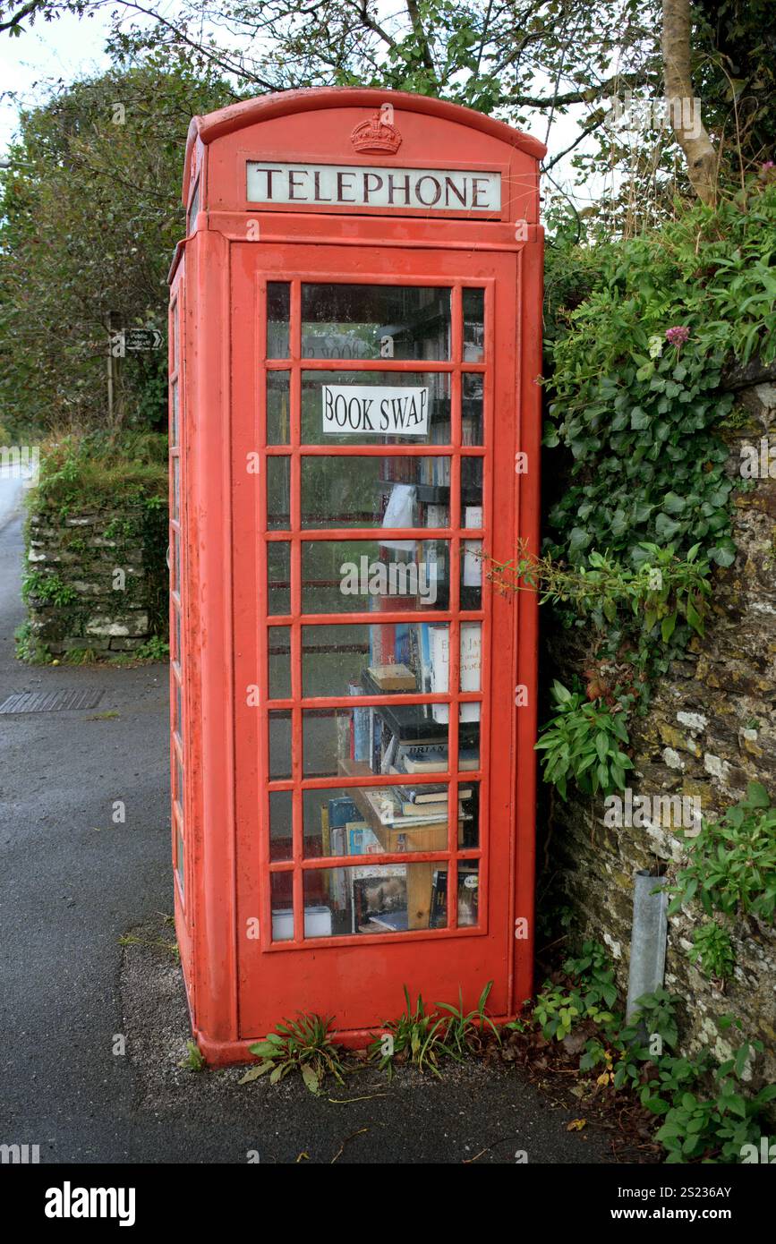 Duloe, Cornwall, UK - October 24, 2021: Red telephone box repurposed as ...