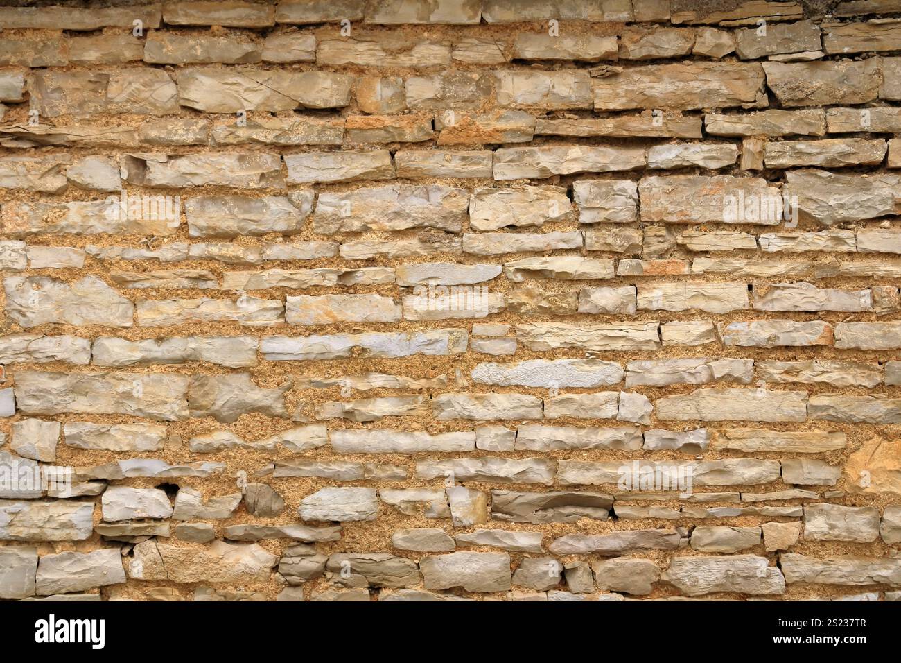 a yellow beige sand color stone brick vertical wall Stock Photo - Alamy