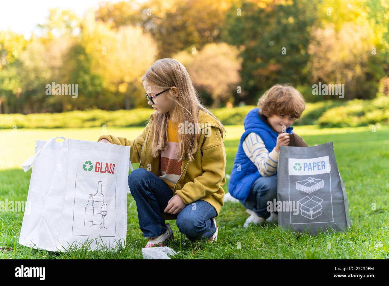 Caucasian kids boy and girl volunteering outdoors cleaning pollution ...