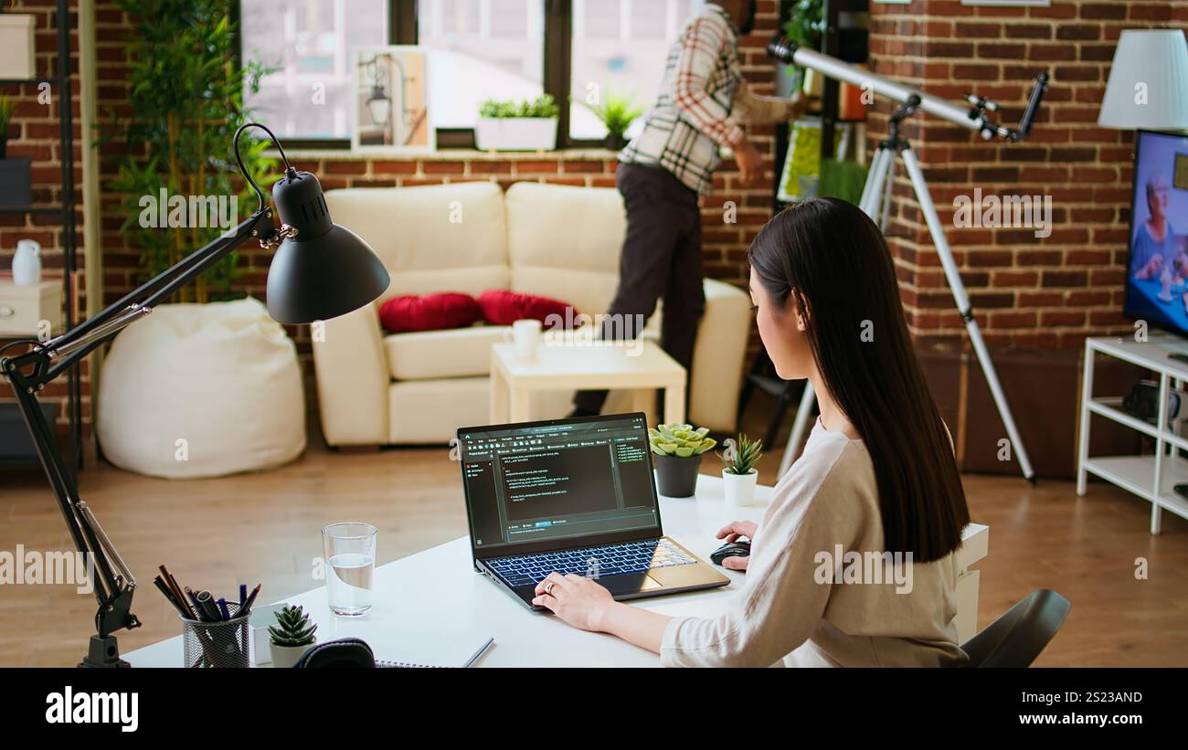 Software developer types programming code in a cozy home office setup ...
