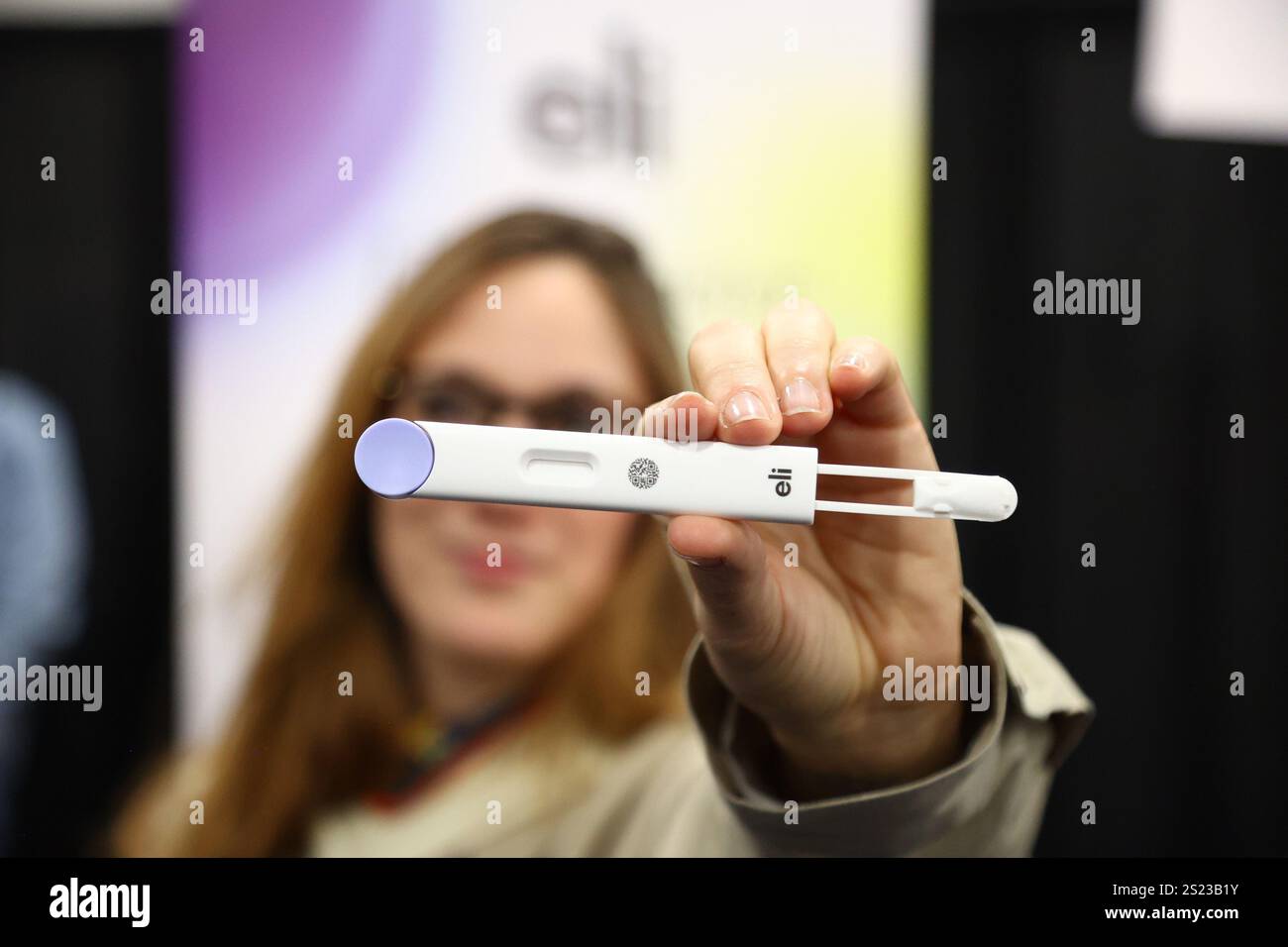 An exhibitor shows off the eli Hormometer, the first instant saliva ...