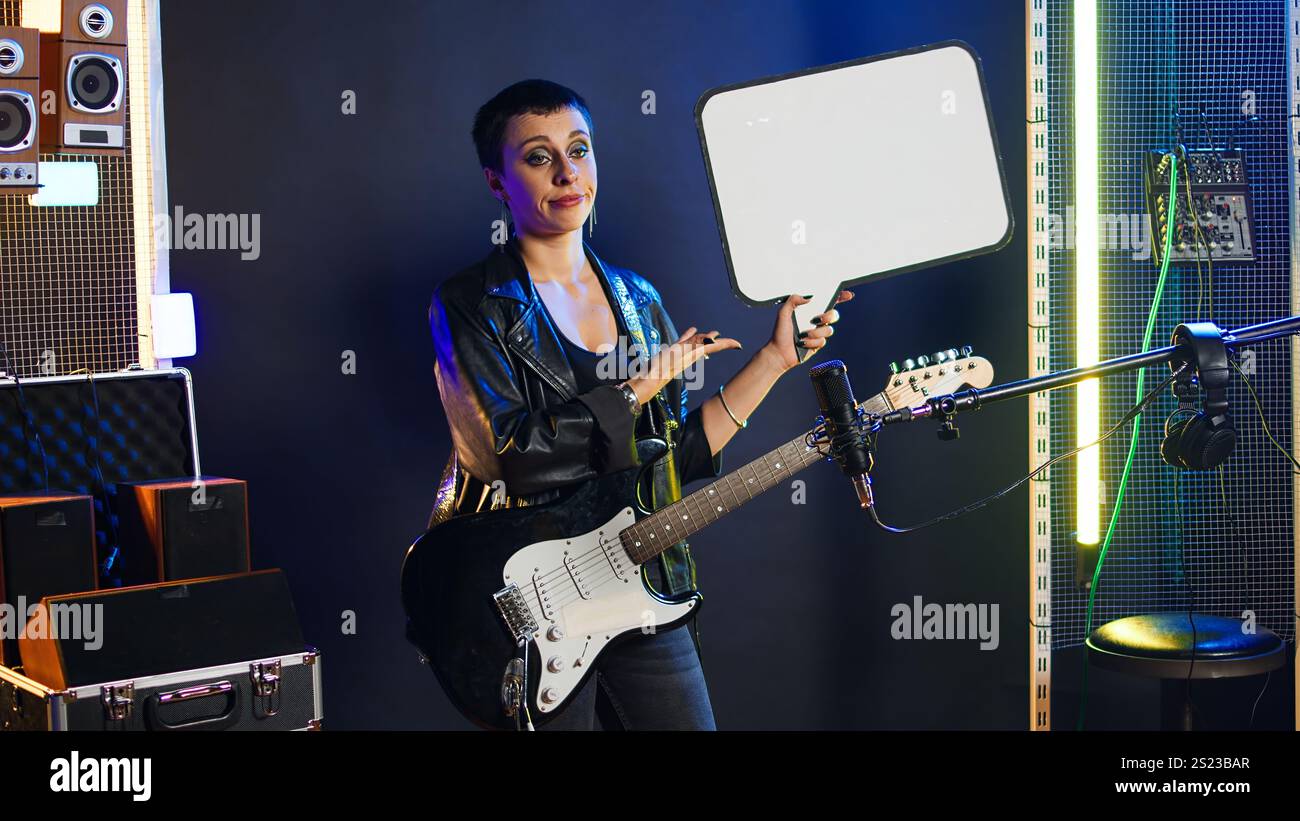 Female rock star performer showing the empty cardboard speech bubble ...